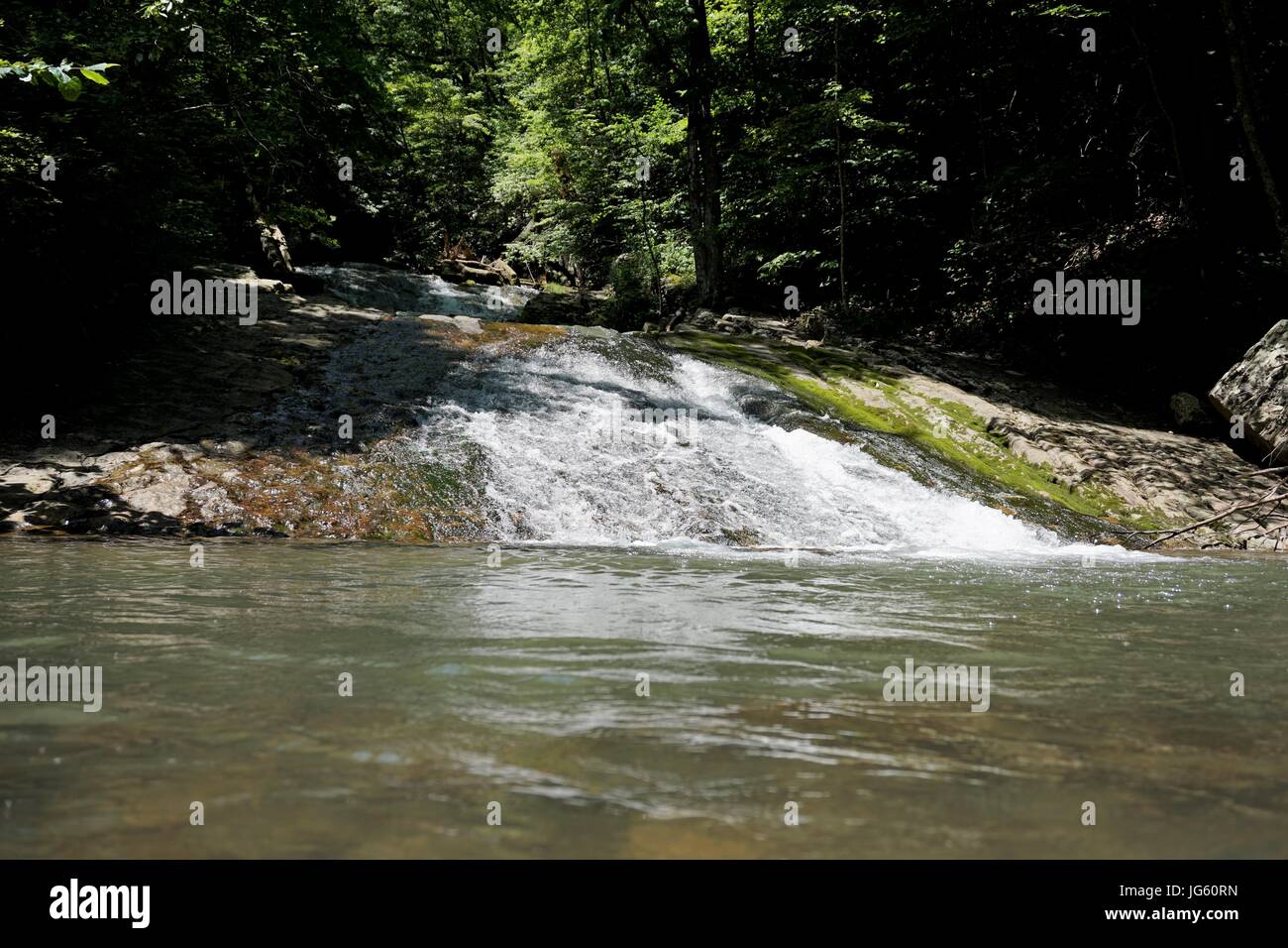 Small water fall flowing into natural pool Stock Photo - Alamy