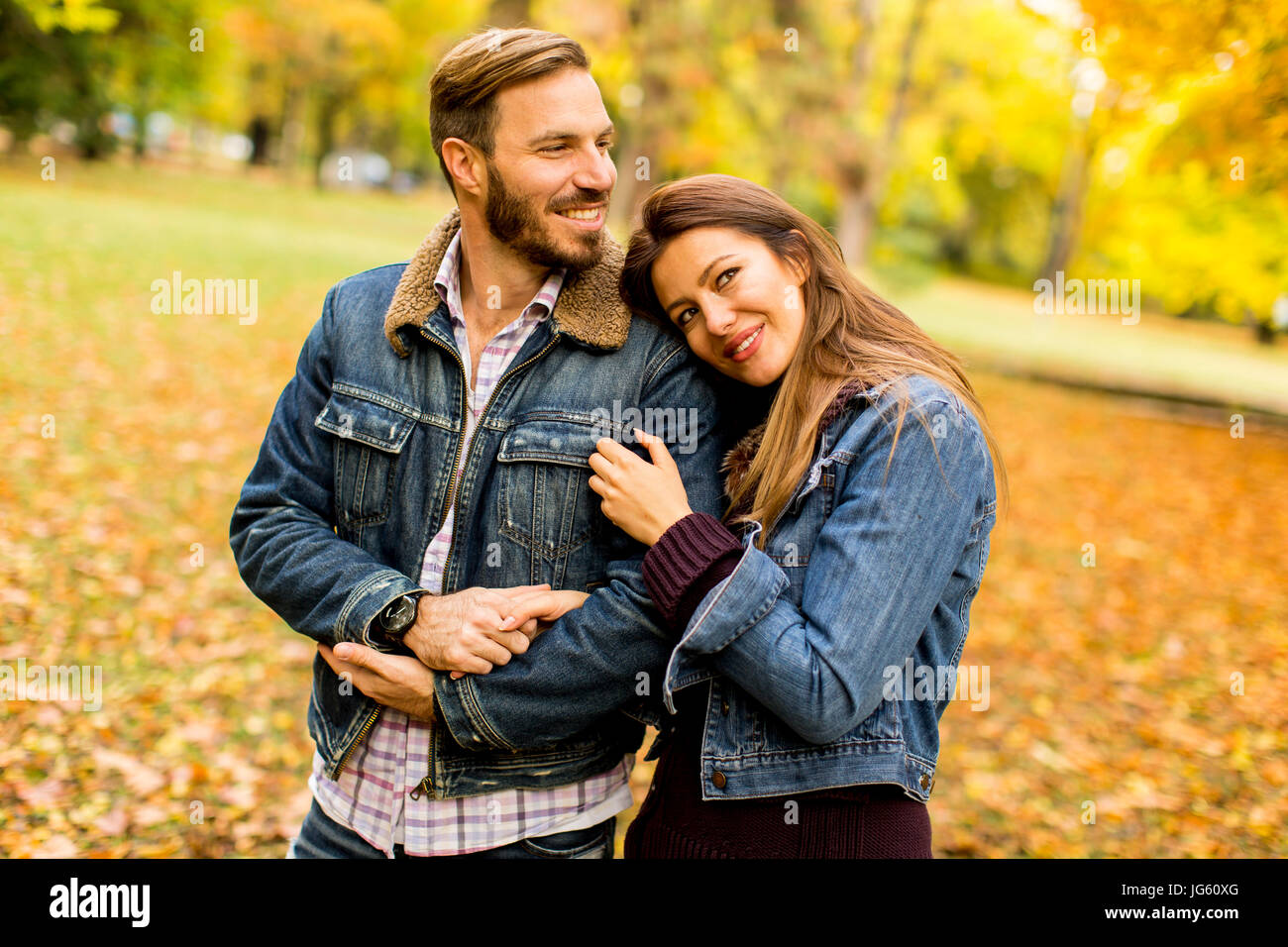 View at smiling couple hugging in autumn park Stock Photo - Alamy