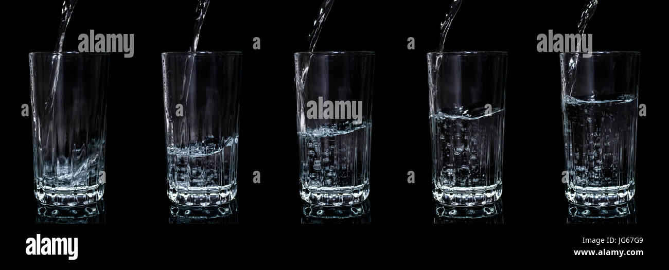 Sequence of a drinking glass being filled with water, black background ...