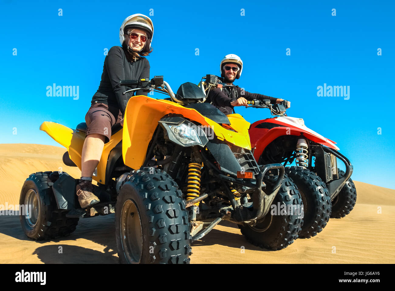 Quad driving people - happy smiling couple bikers in sand desert Stock ...