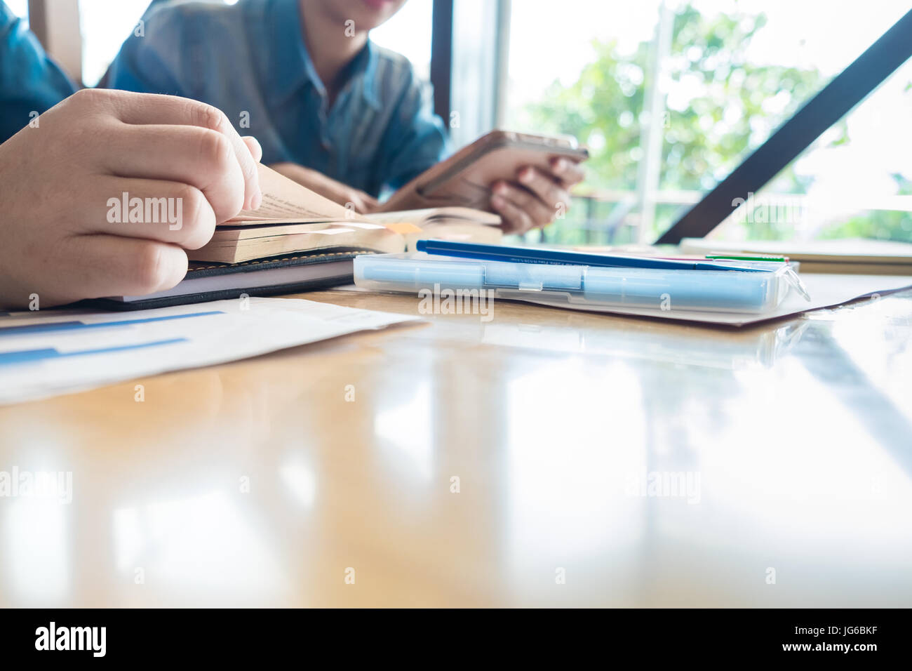 Two students studying together from text book, lifestyle tutoring ...