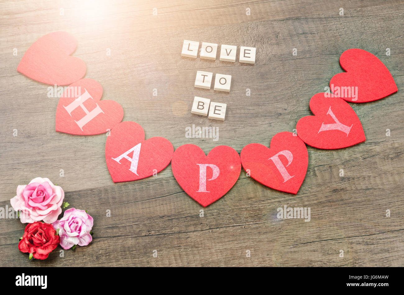 Love to be happy word with red heart and roses on wooden background ...