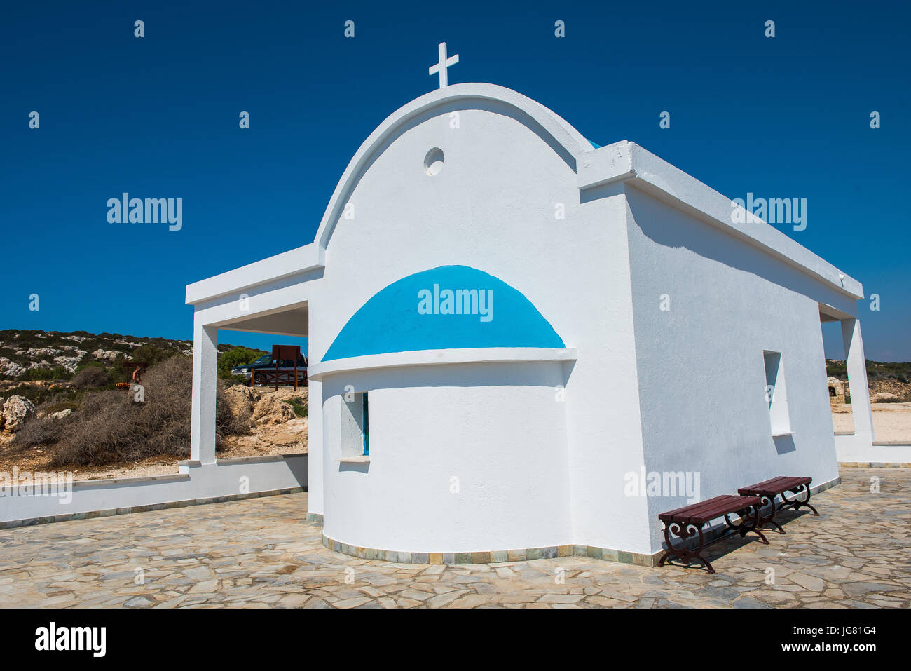 Traditional Greek white chapel with a blue roof on the seaside. Agioi ...
