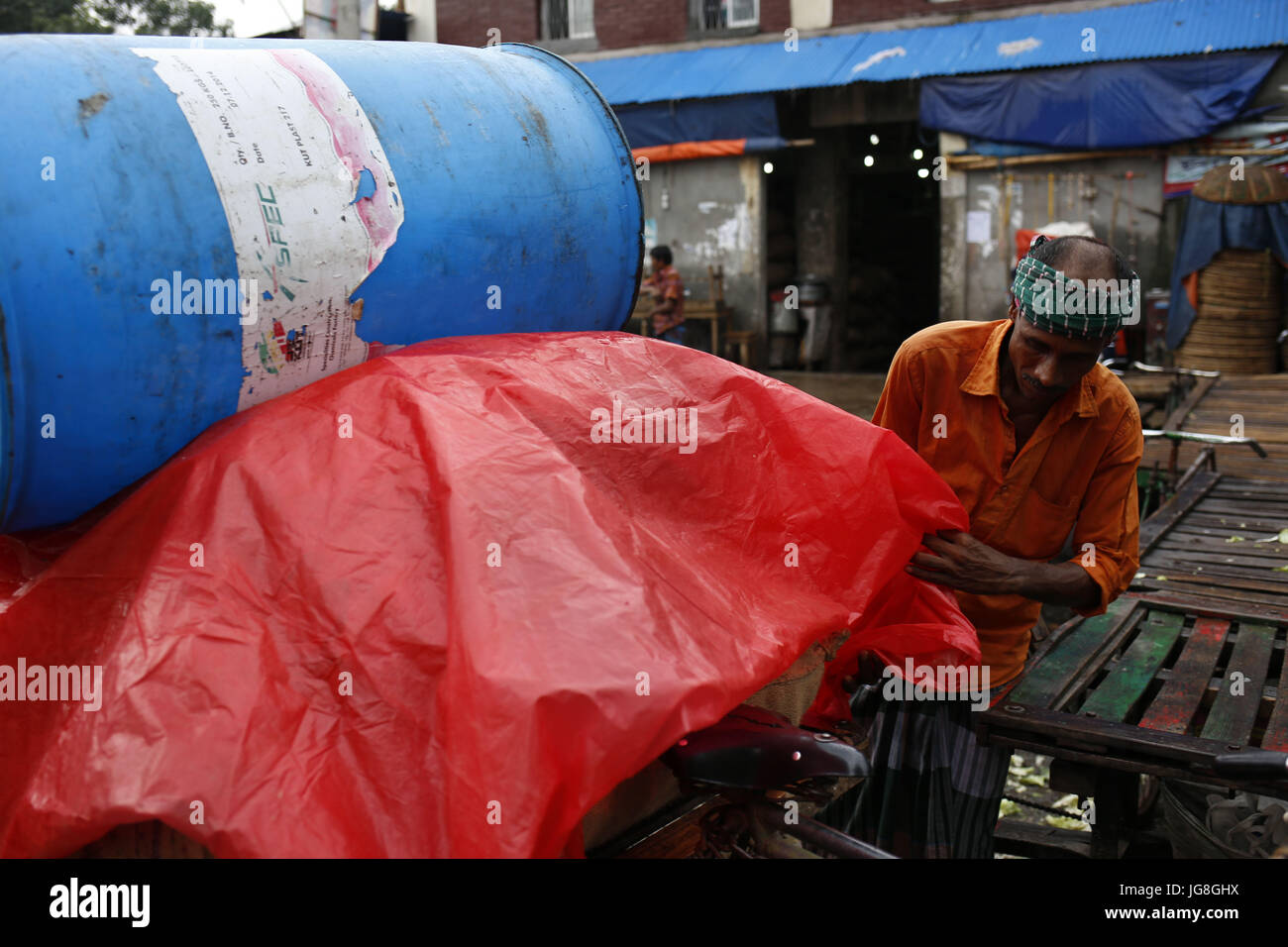 Dhaka, Bangladesh. 4th July, 2017. A rickshaw ""“van puller cover goods ...