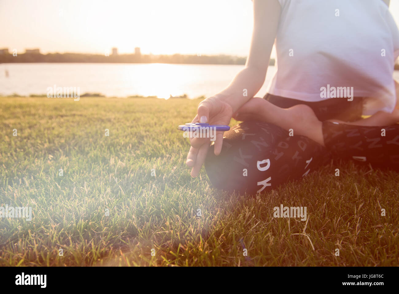 A teenager girl in lotus pose with spinners. Girl with a Tri Fidget ...