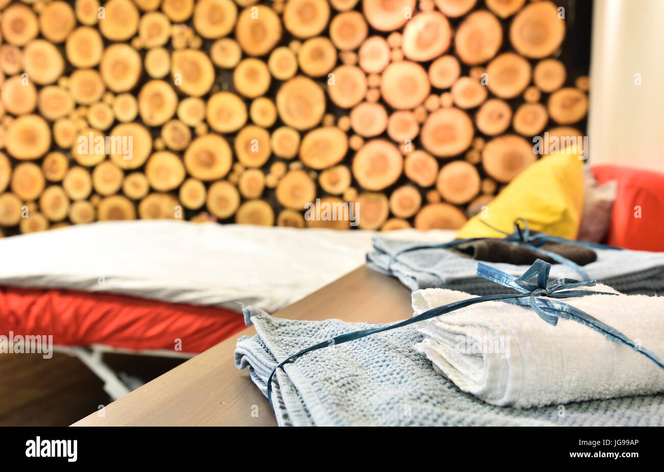 Tree trunks, logs taped on a wall. House interior detail with a bed and ...