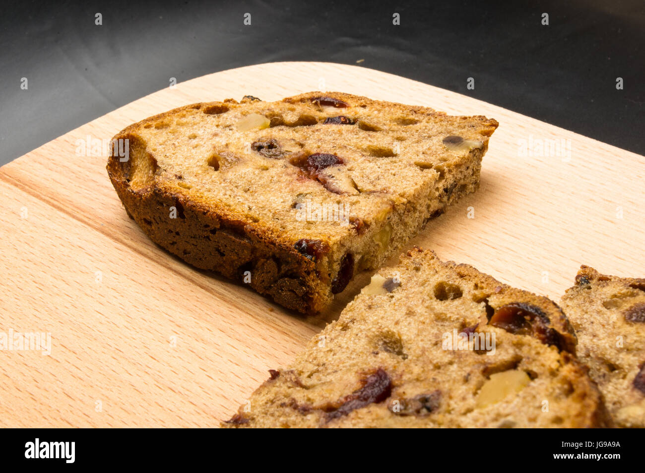 Slices of malt bread handmade with nuts, raisins and cranberries on ...