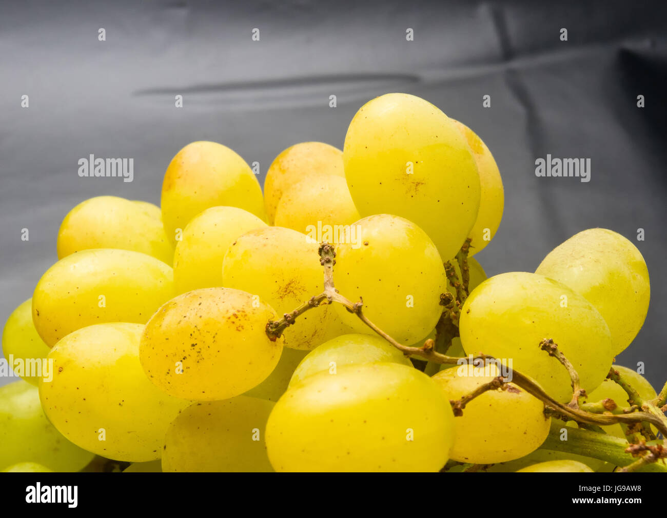 Large grapes cluster amber color on black background Stock Photo - Alamy