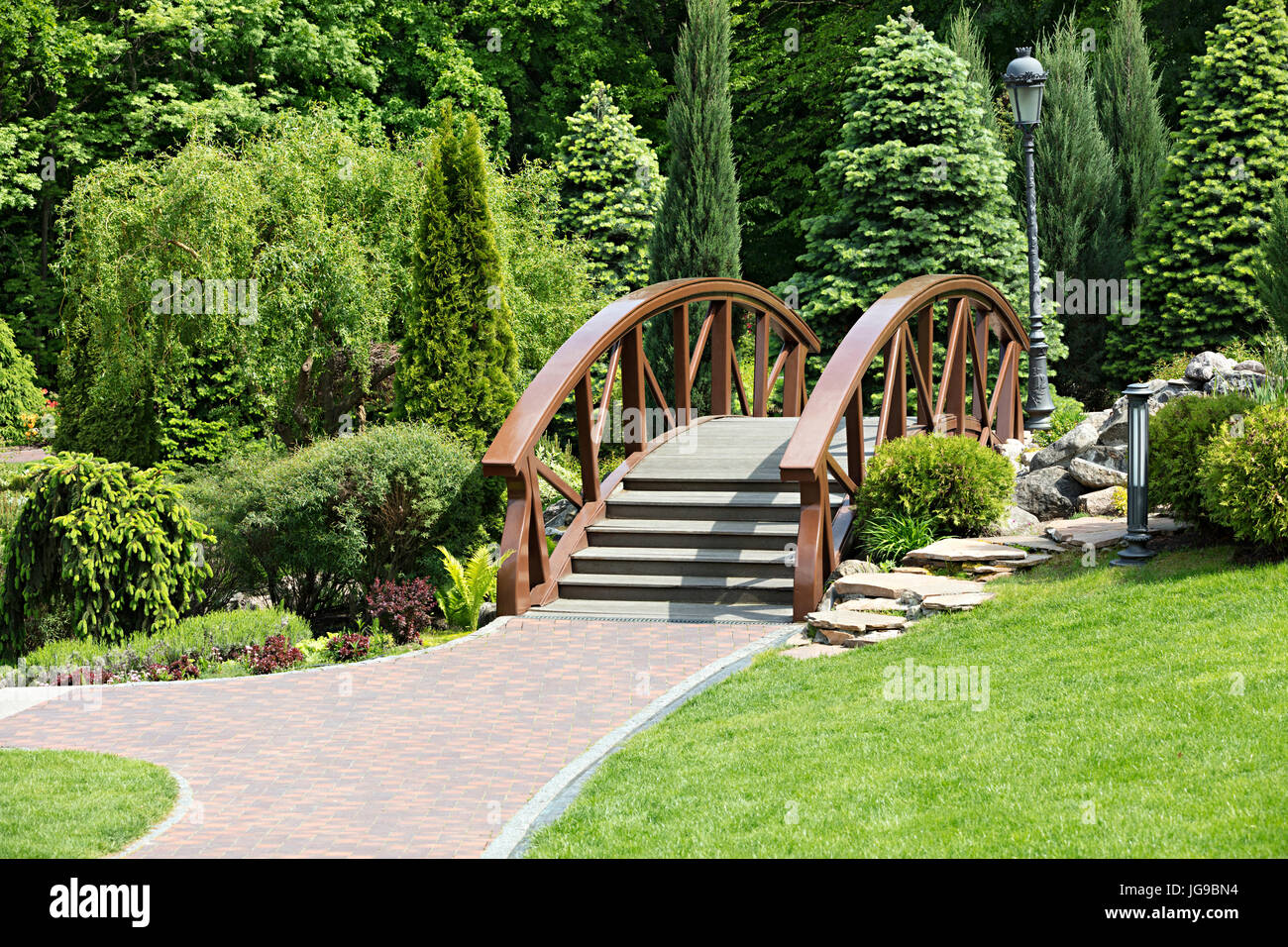 A small wooden bridge over the creek and paved sidewalk beautifully ...