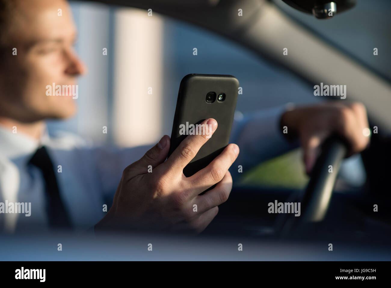young man with the phone while driving Stock Photo - Alamy