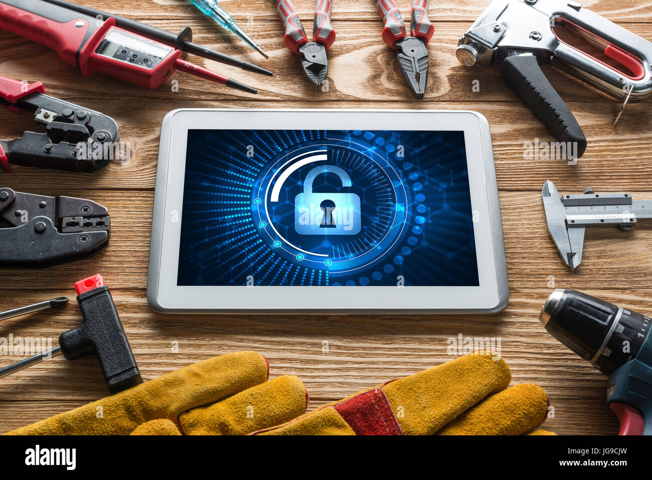Tablet pc with security concept on screen and industrial tools around ...