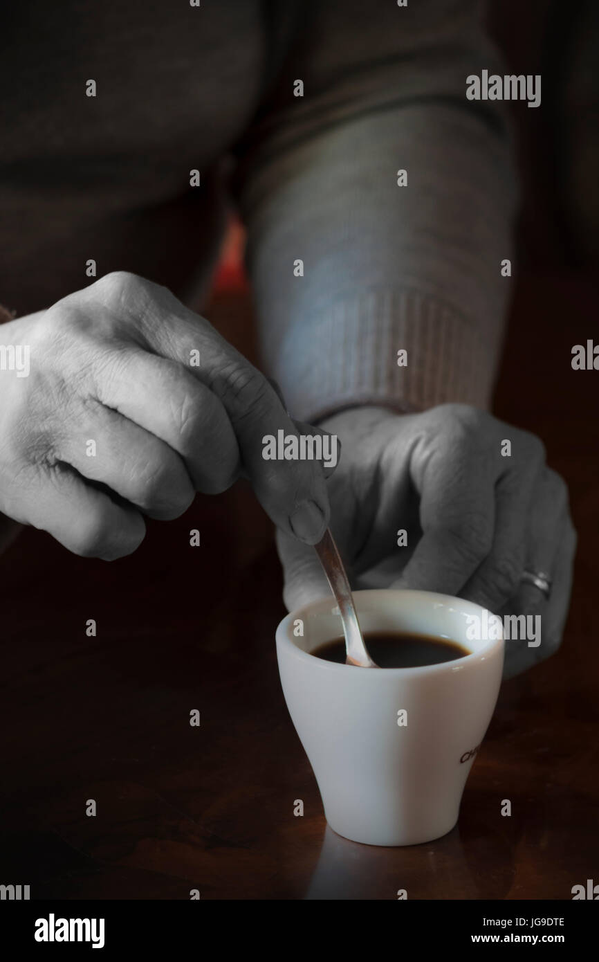 Mixing coffee with black and white hands Stock Photo - Alamy