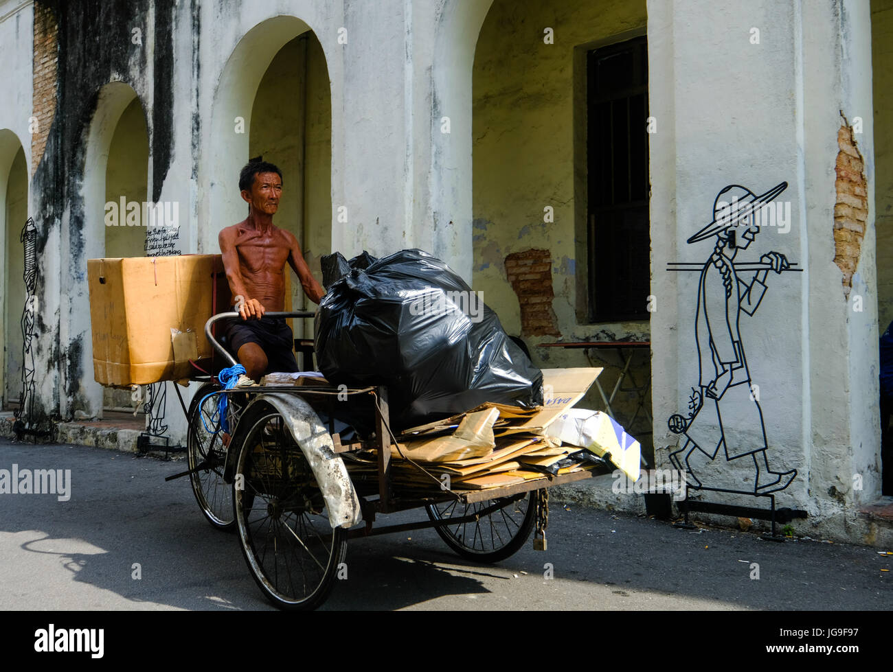 A Chinese man collects re-cyclable goods from his bike in Georgetown, Penang, Malaysia Stock ...
