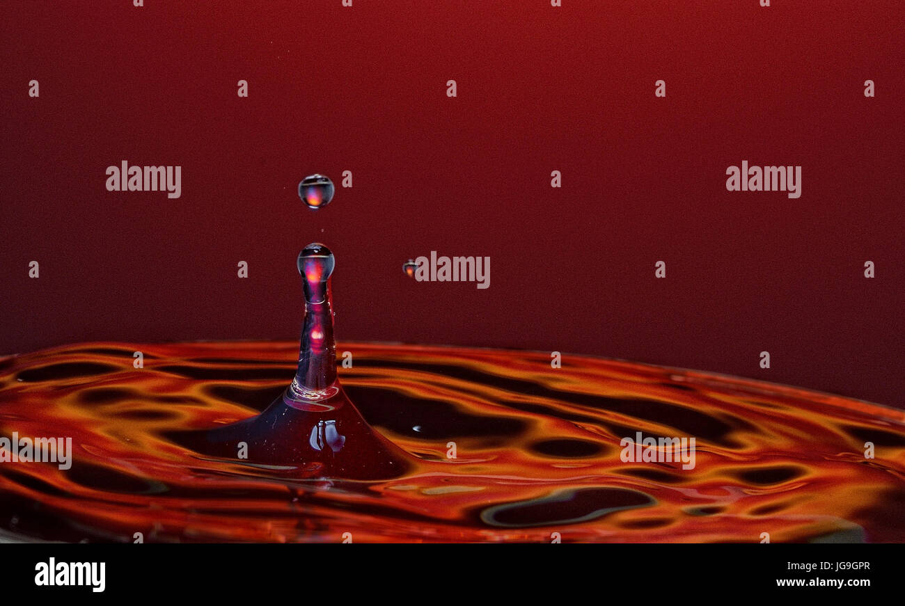 Beautiful drop of water spray in red Stock Photo - Alamy