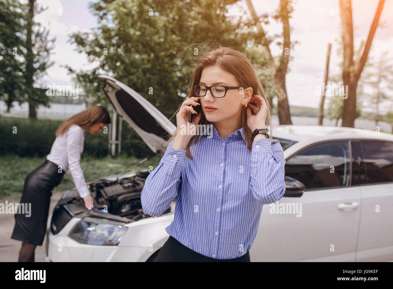 two girls on the road trying to fix their car Stock Photo - Alamy