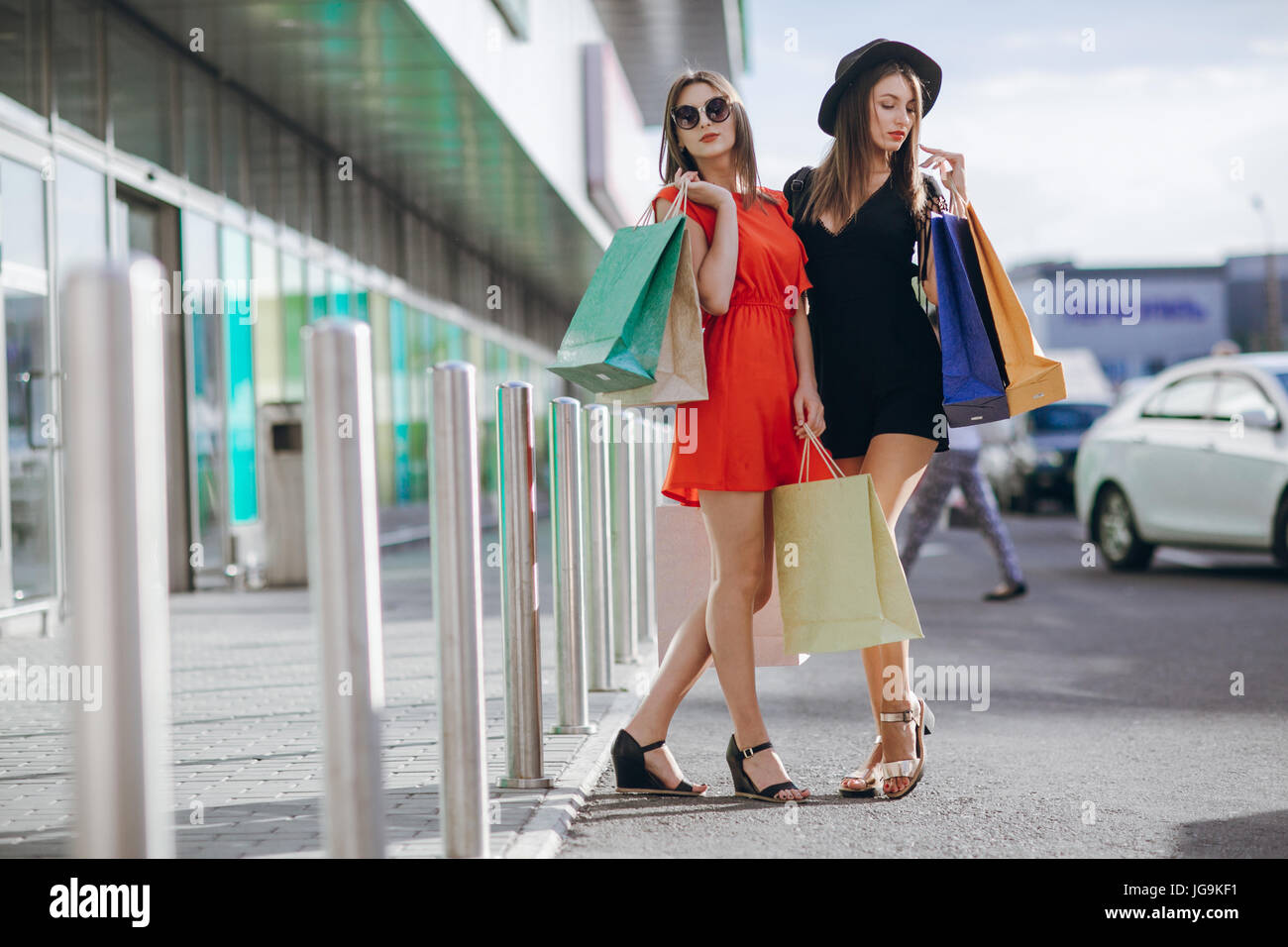 two beautiful young women walk to the shops and make purchases Stock ...