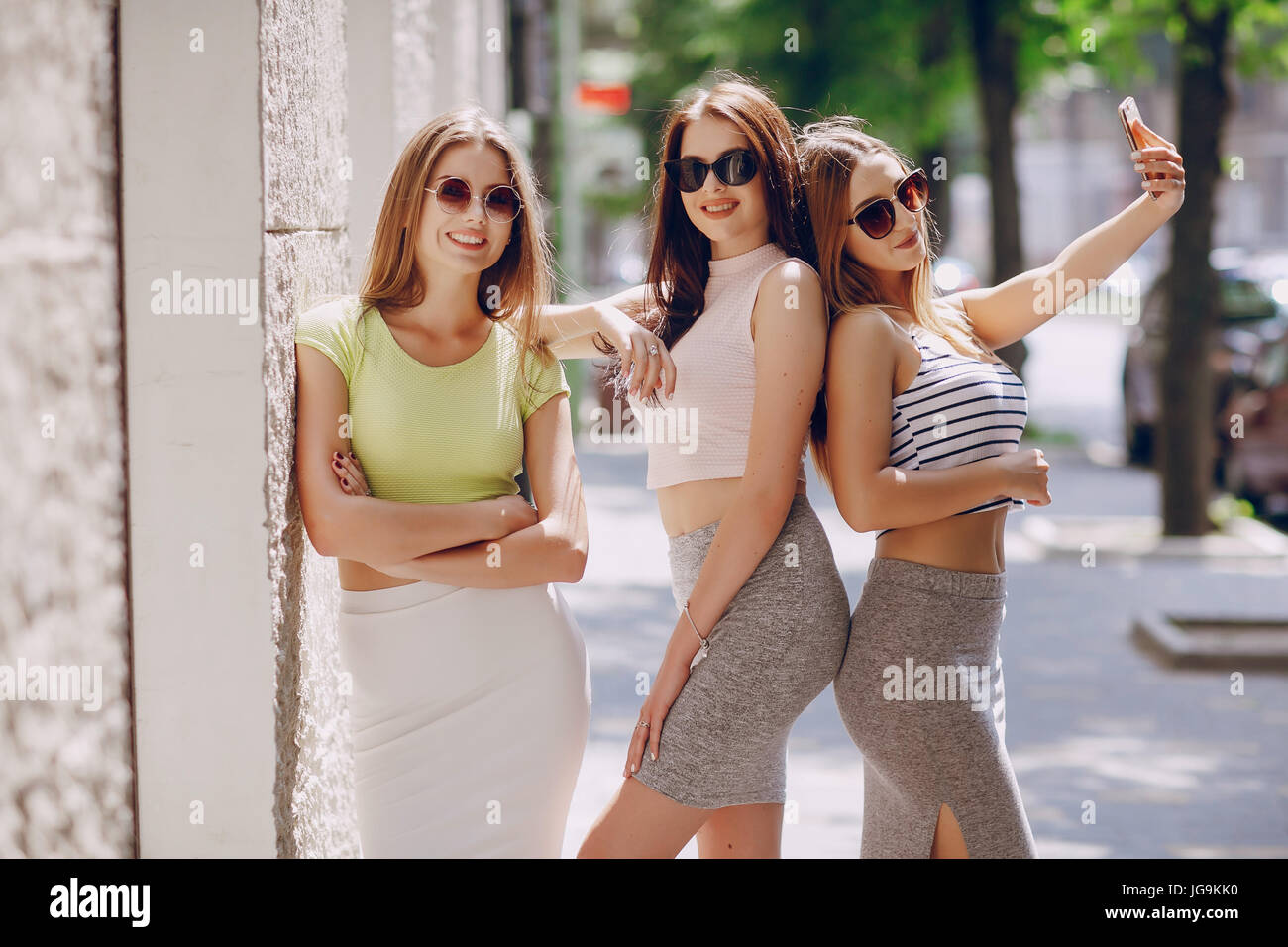 three beautiful girls walking around the city Stock Photo - Alamy
