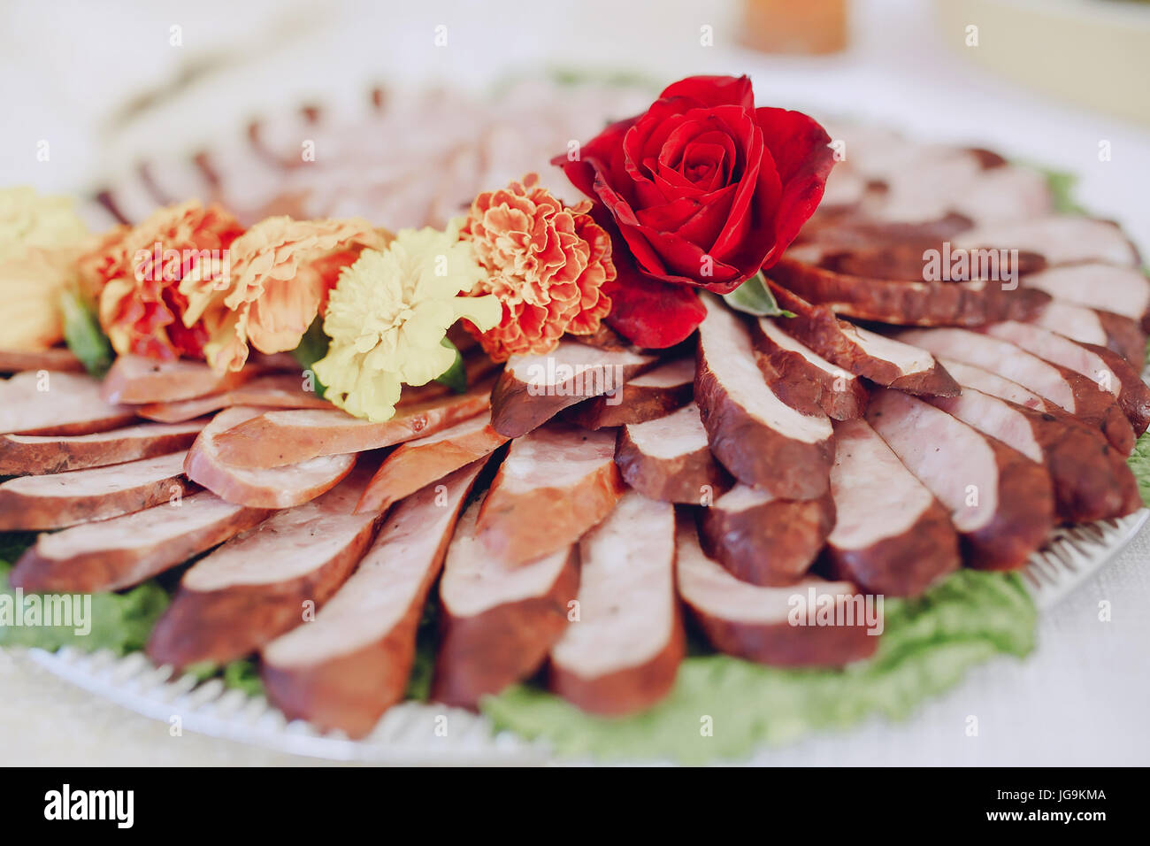 on the table is a plate of salami decorated with flowers Stock Photo ...