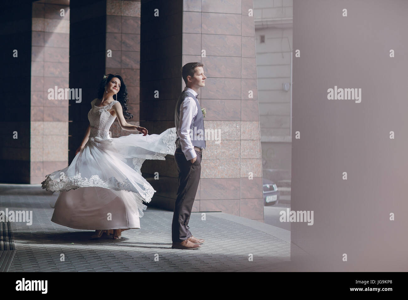 bride and groom stand near tall columns Stock Photo - Alamy