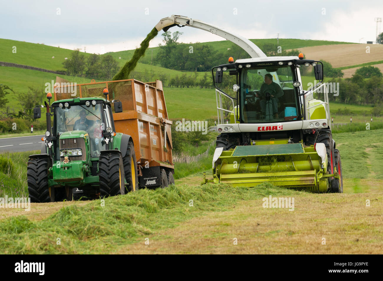 Silage lifting with John Deere tractor and Claas Chopper Stock Photo ...