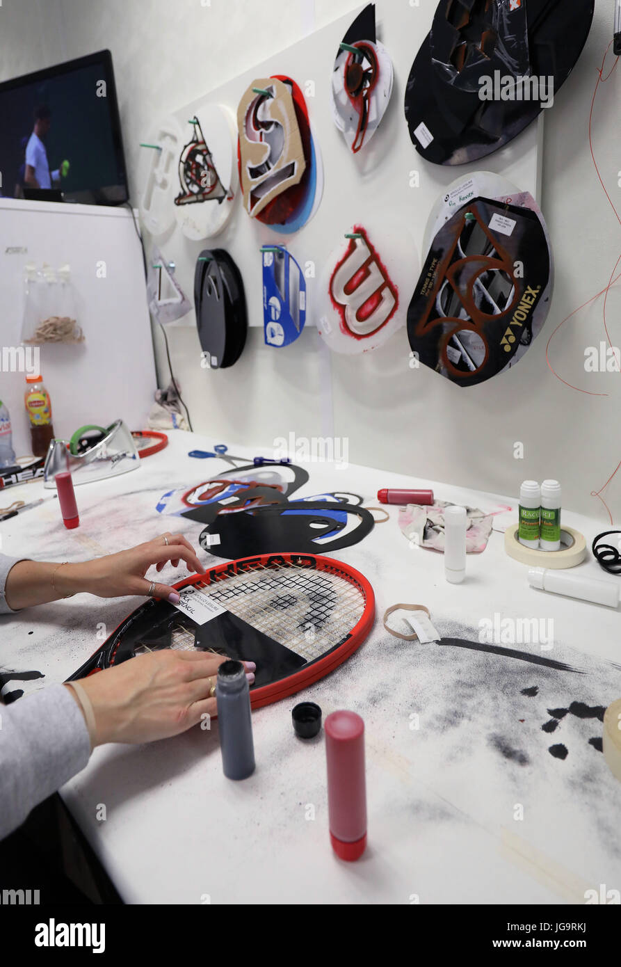 A branding logo is applied to a racket in the Stringing Room on day two ...