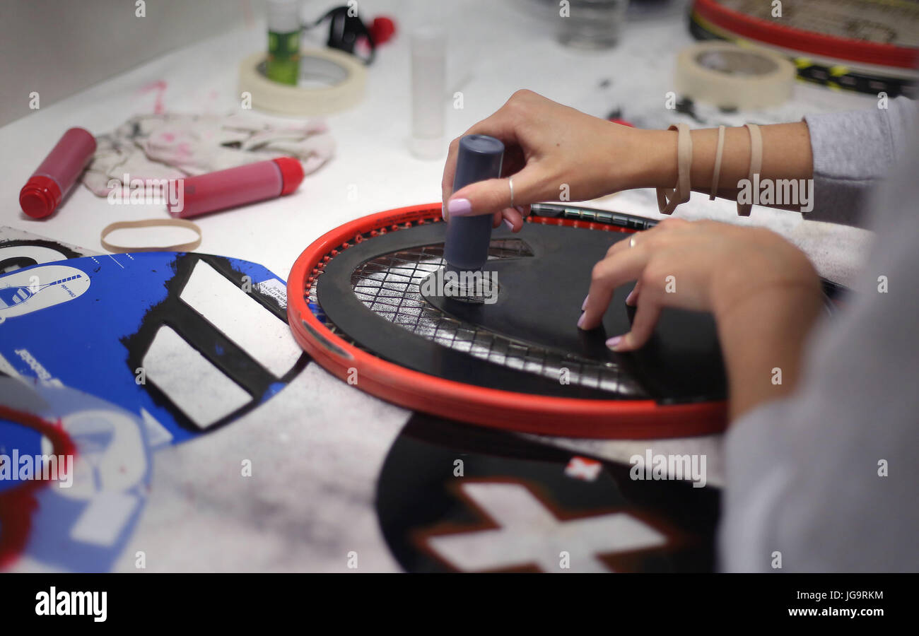 A branding logo is applied to a racket in the Stringing Room on day two ...