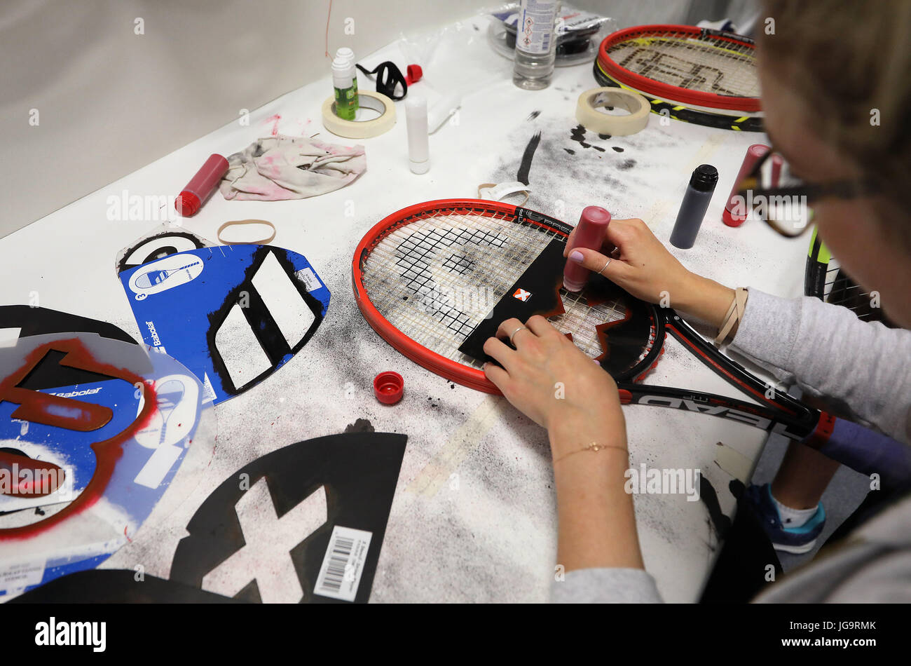 A branding logo is applied to a racket in the Stringing Room on day two ...