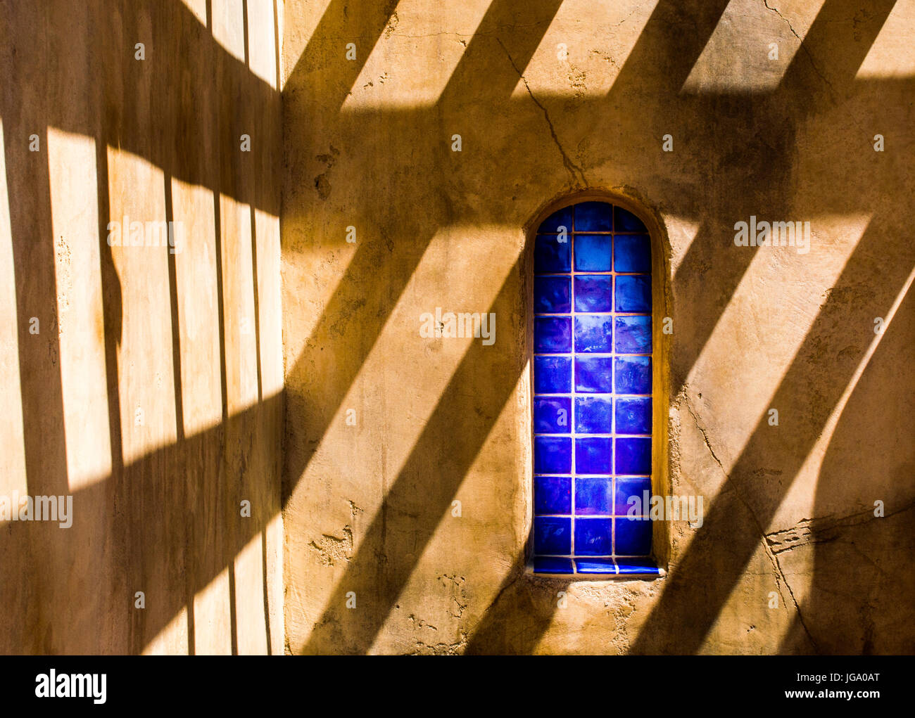 blue tile arched window in corner with shadows Stock Photo - Alamy