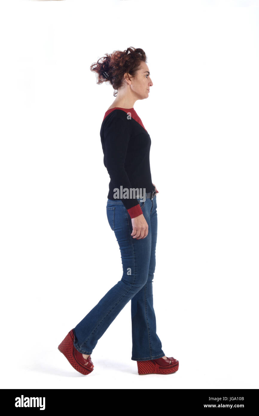 Woman with blue jeans walking on a white background Stock Photo - Alamy