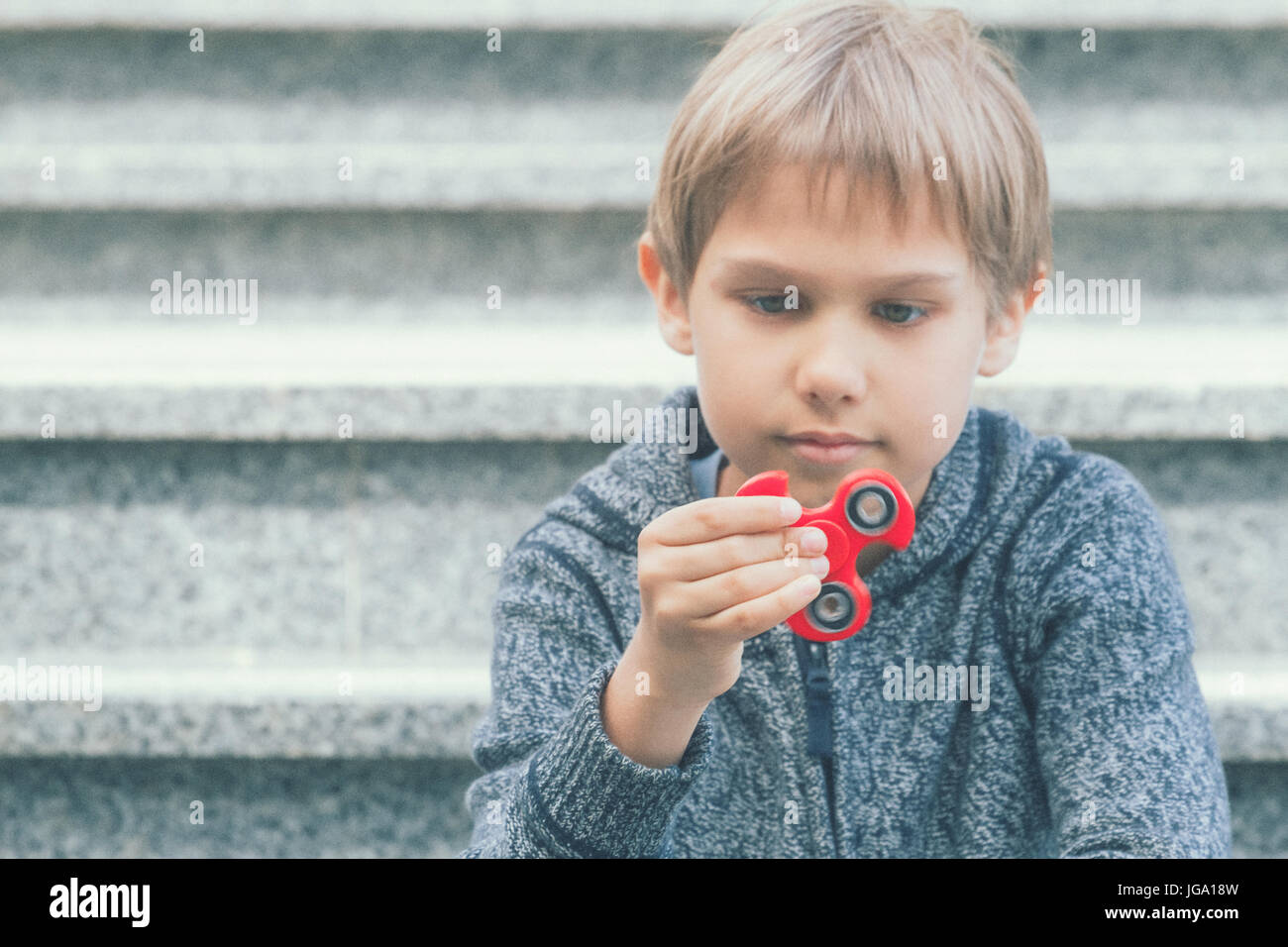 Boy with a fidget spinner outdoors Stock Photo - Alamy