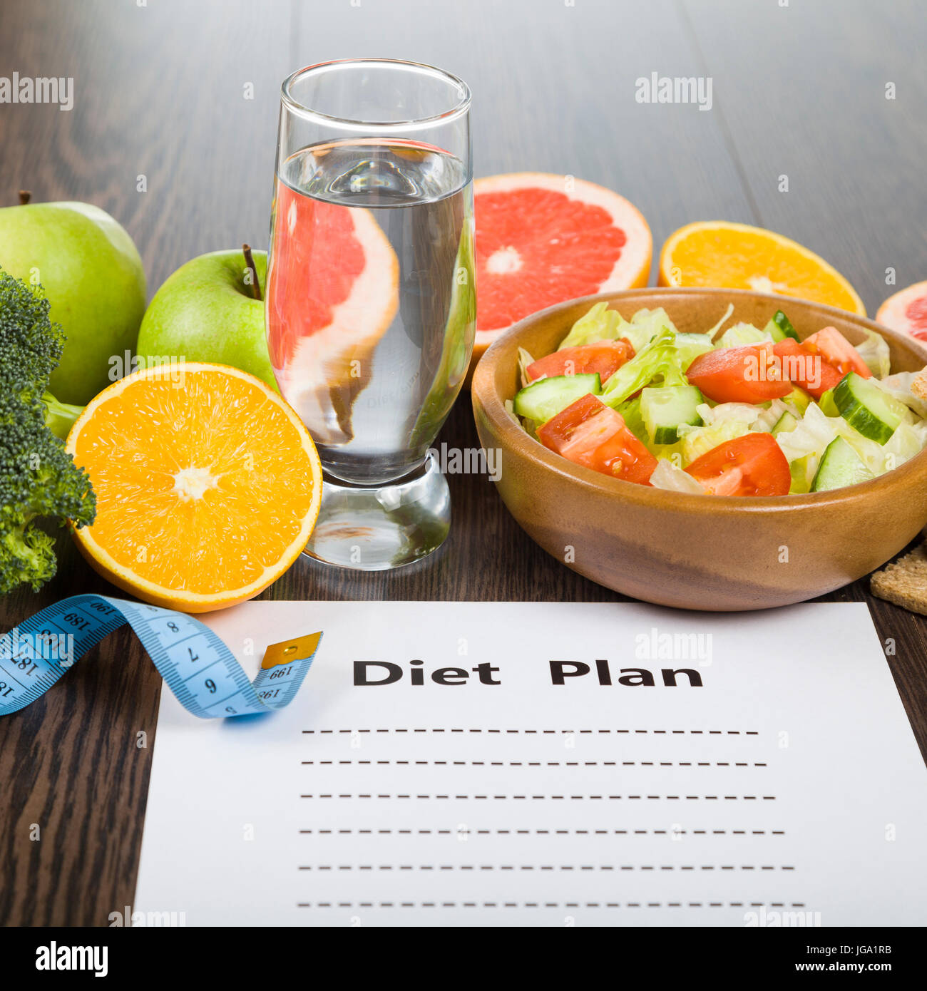 Food and sheet of paper with a diet plan on a dark wooden table ...