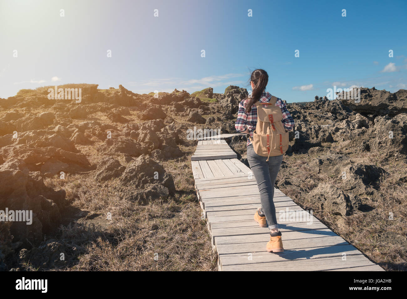 asian traveler along wooden path walking beside many attractive rocks ...
