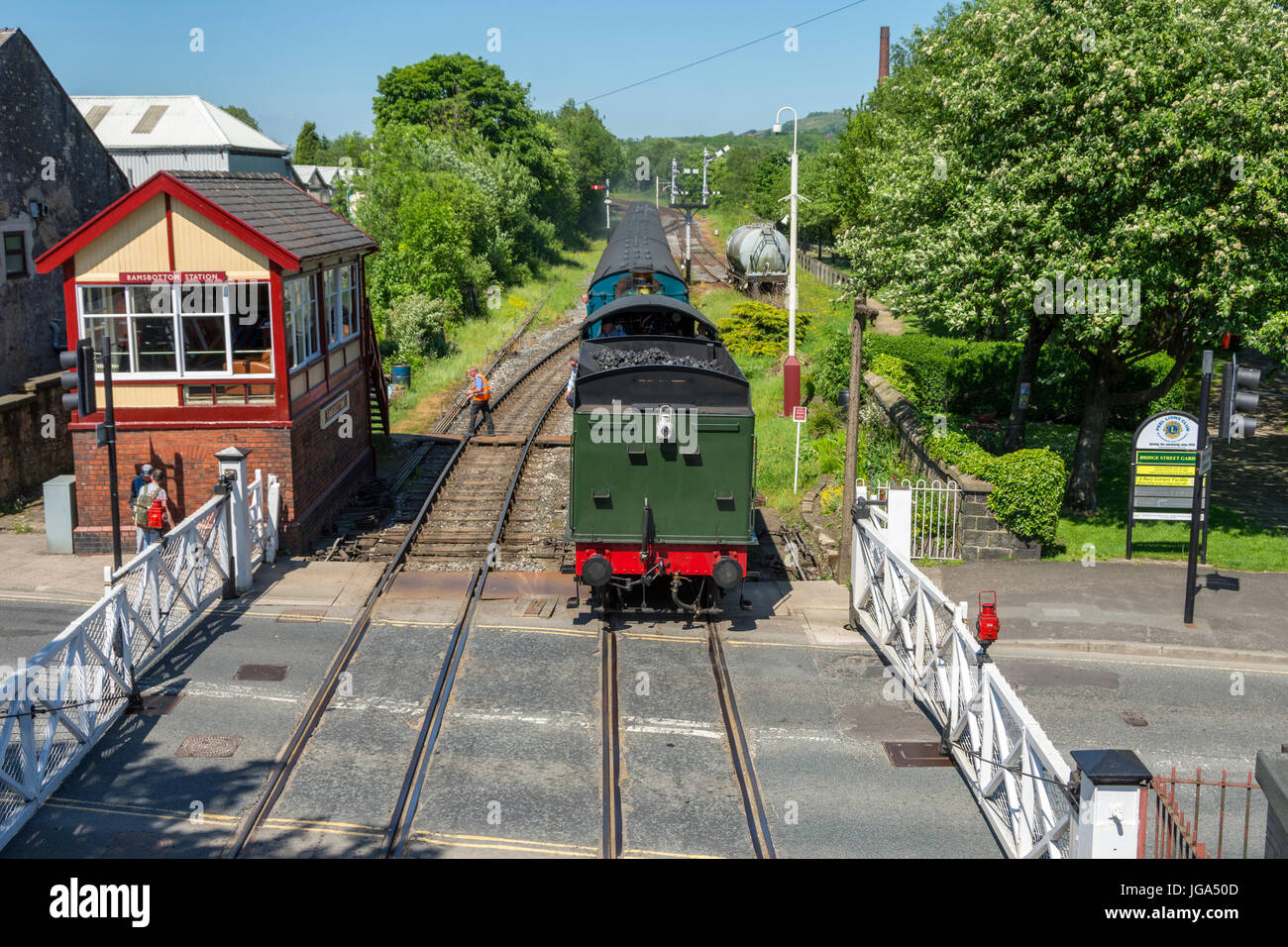 Steam hauled train passing the signal box and level crossing, on the ...
