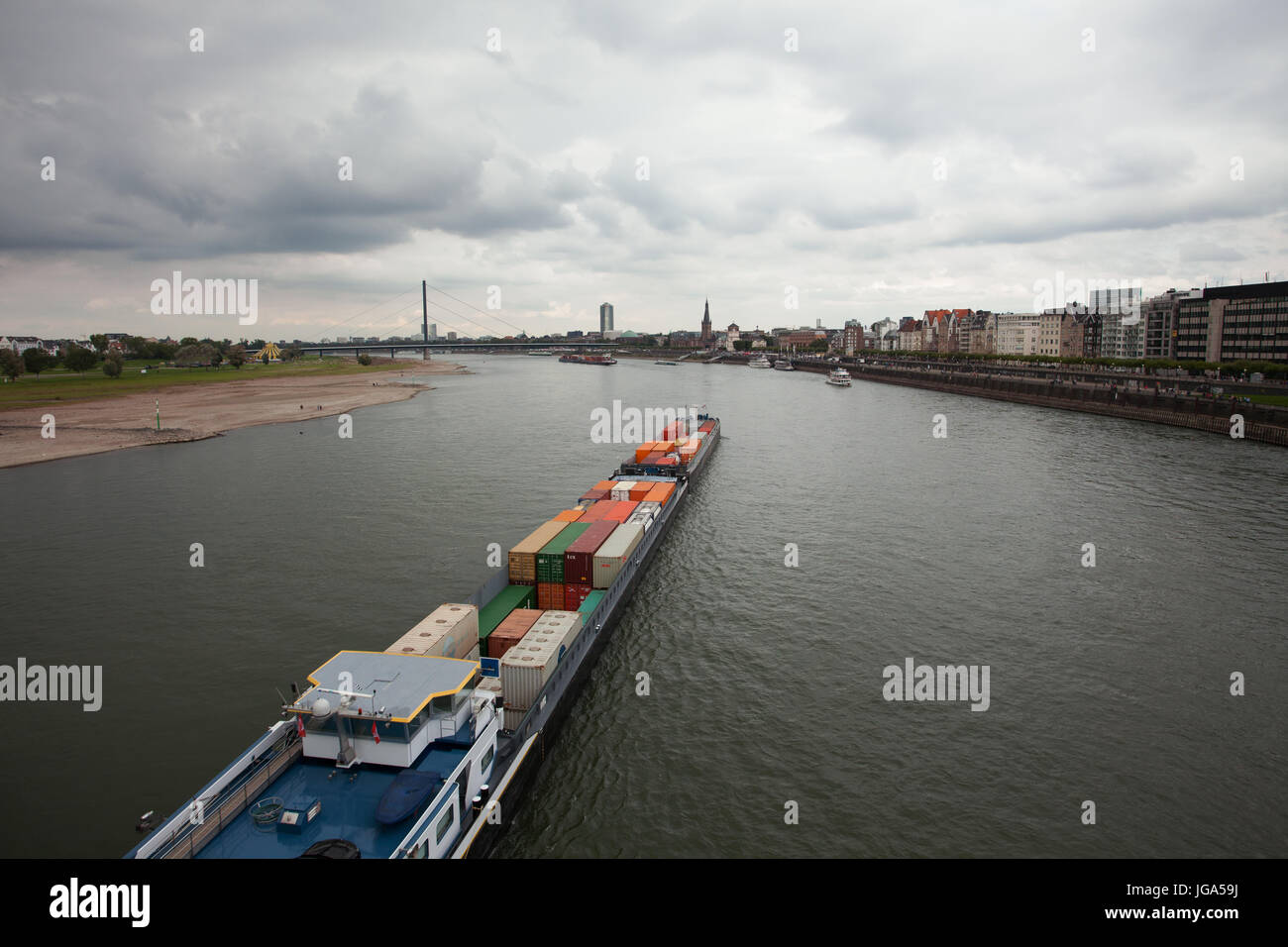 Selfpropelled container cargo boat at Rhyne river, passing through city ...