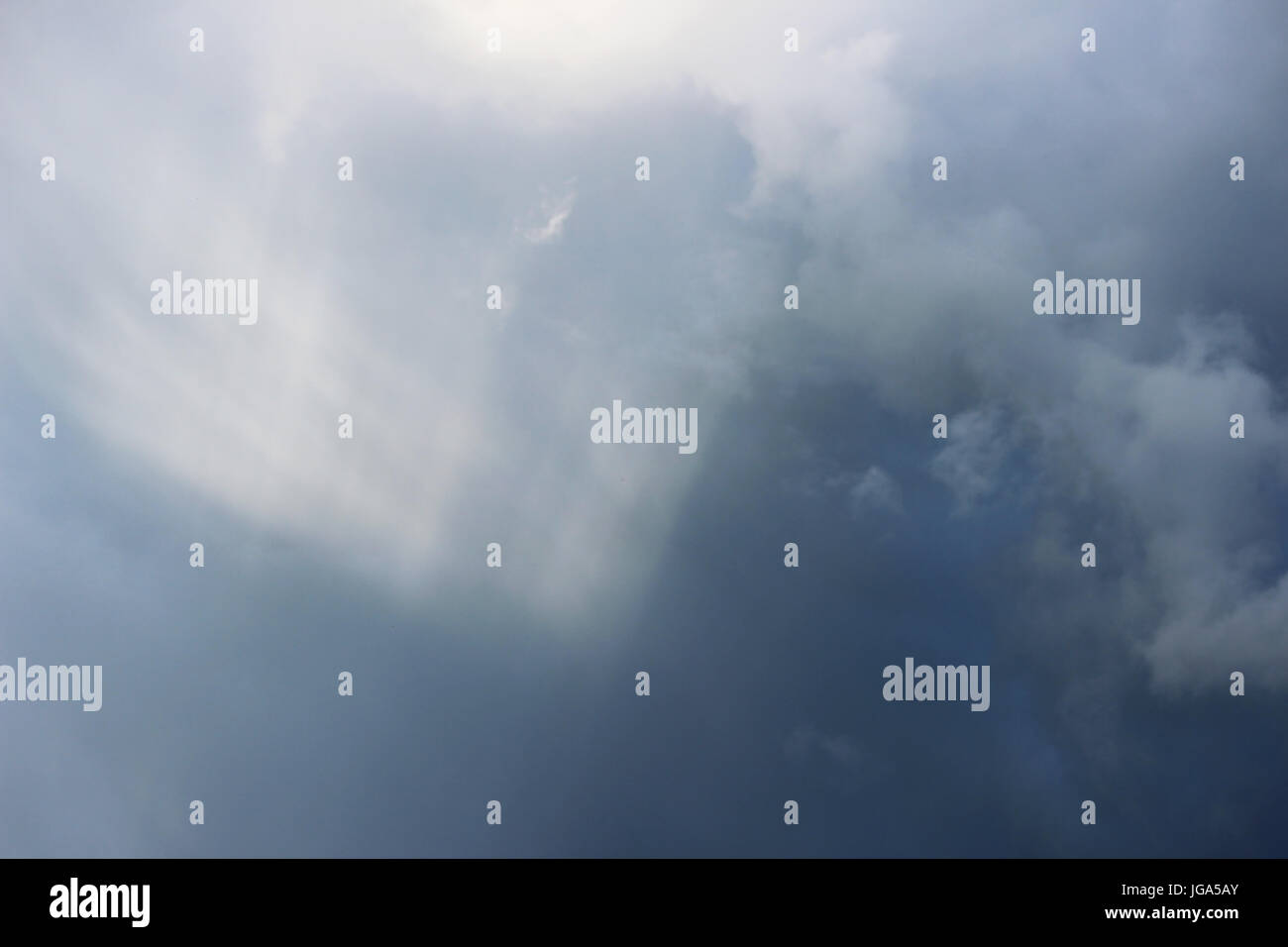 Unusual glow of sunlight through dark gray rain clouds before a ...