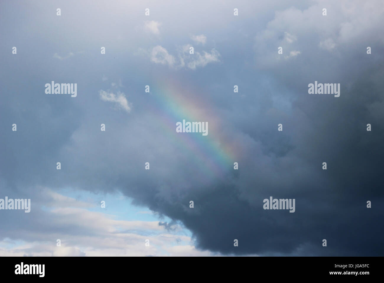 bright colorful wide colorful rainbow after the storm in the gray sky ...