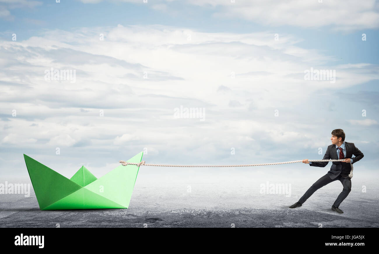 Successful businessman pulling with rope paper boat Stock Photo - Alamy
