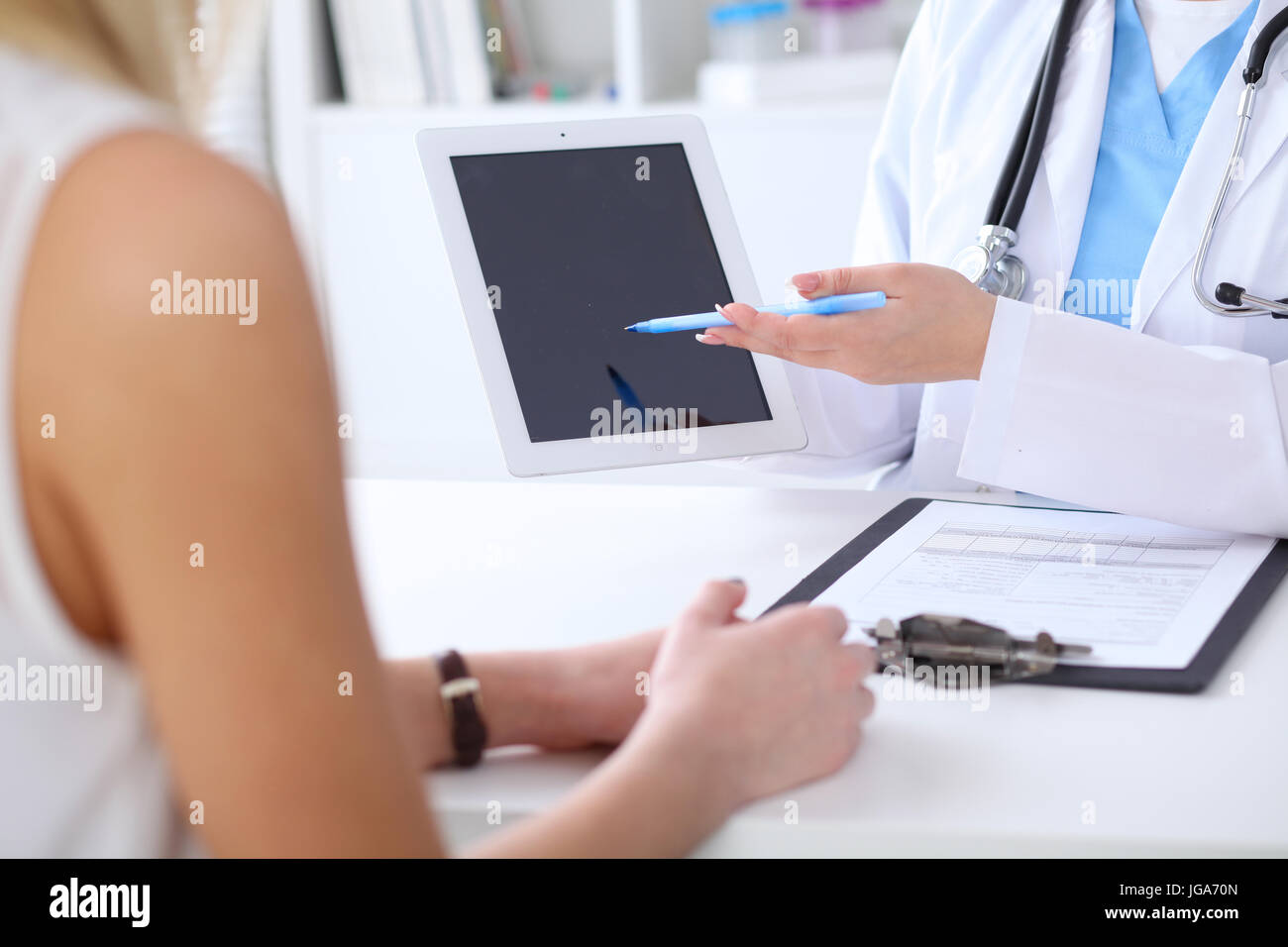 Close up of a doctor and patient hands while phisician pointing into ...