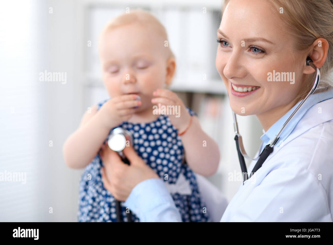Pediatrician is taking care of baby in hospital. Little girl is being ...