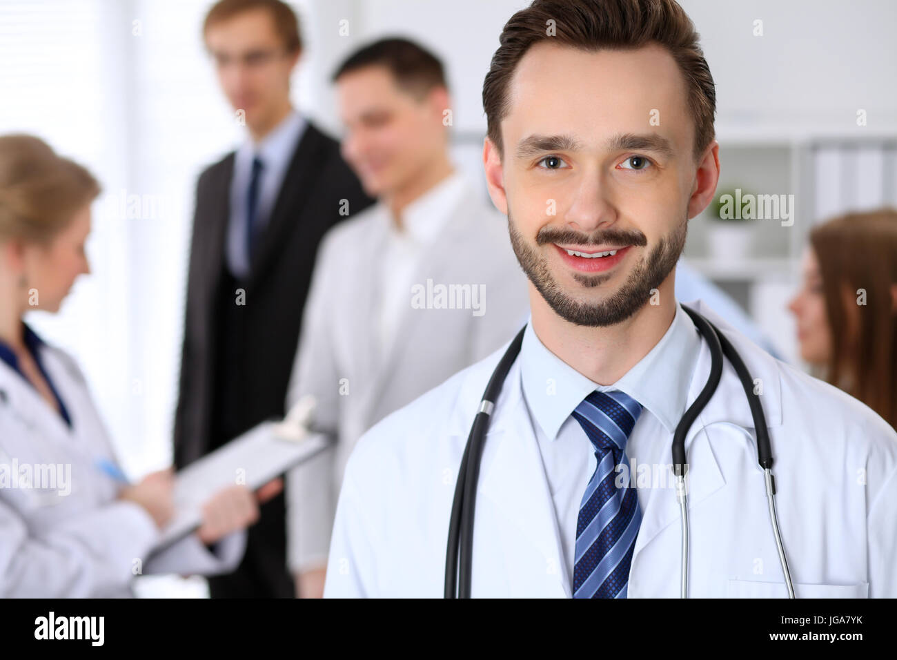 Friendly male doctor on the background doctor and many patients Stock ...