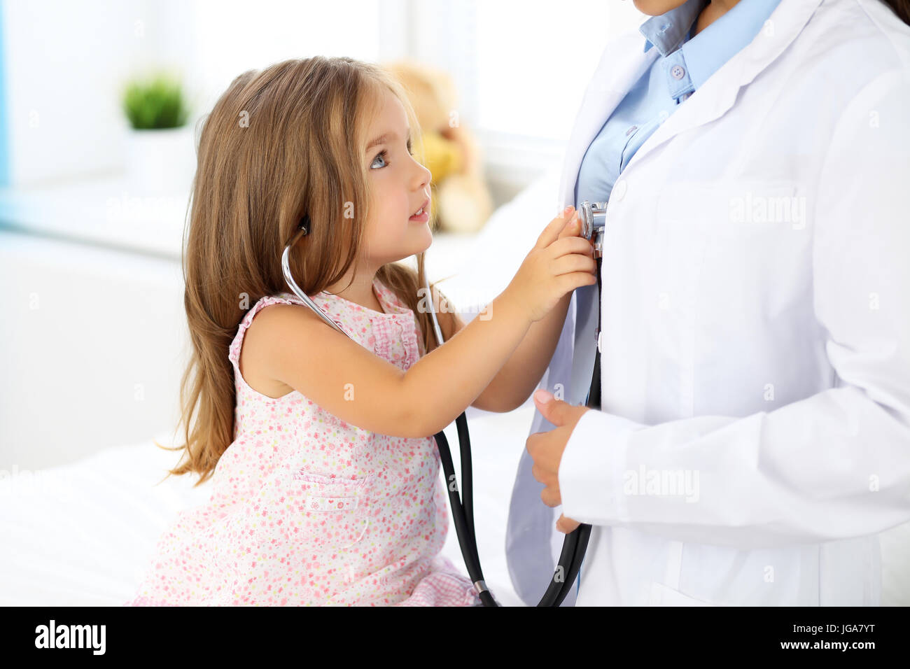 Happy little girl at health exam at doctor's office Stock Photo - Alamy