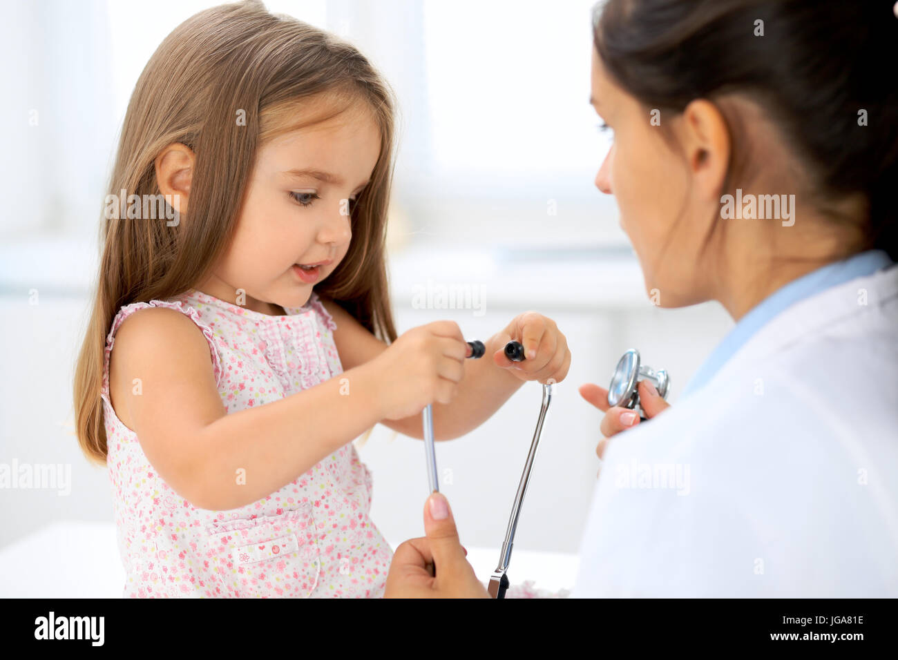 Happy little girl at health exam at doctor's office Stock Photo - Alamy
