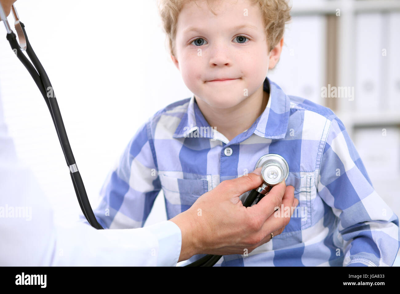 Doctor examining a child patient by stethoscope Stock Photo - Alamy