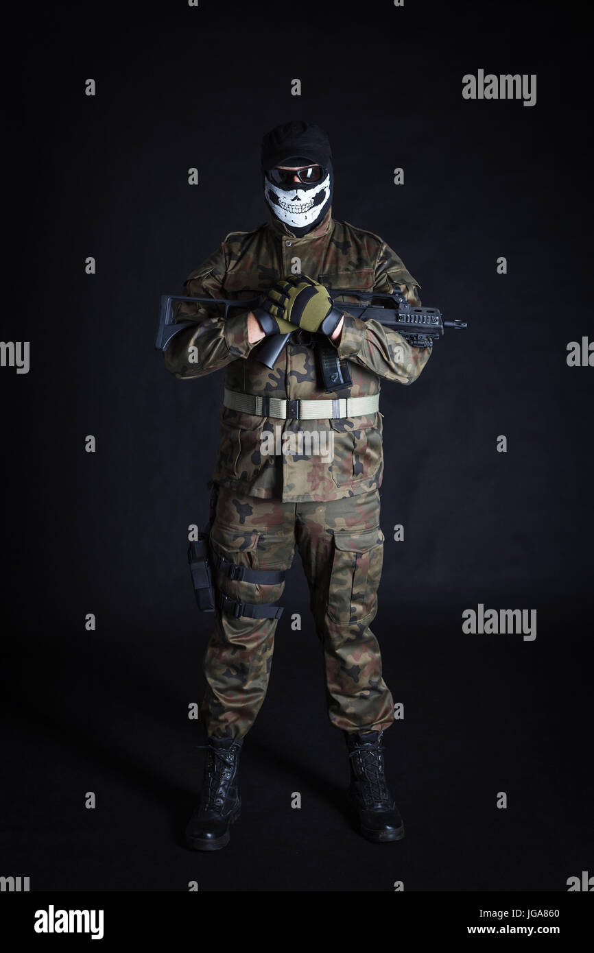 Anti terrorist in black mask holding a gun on black background Stock ...