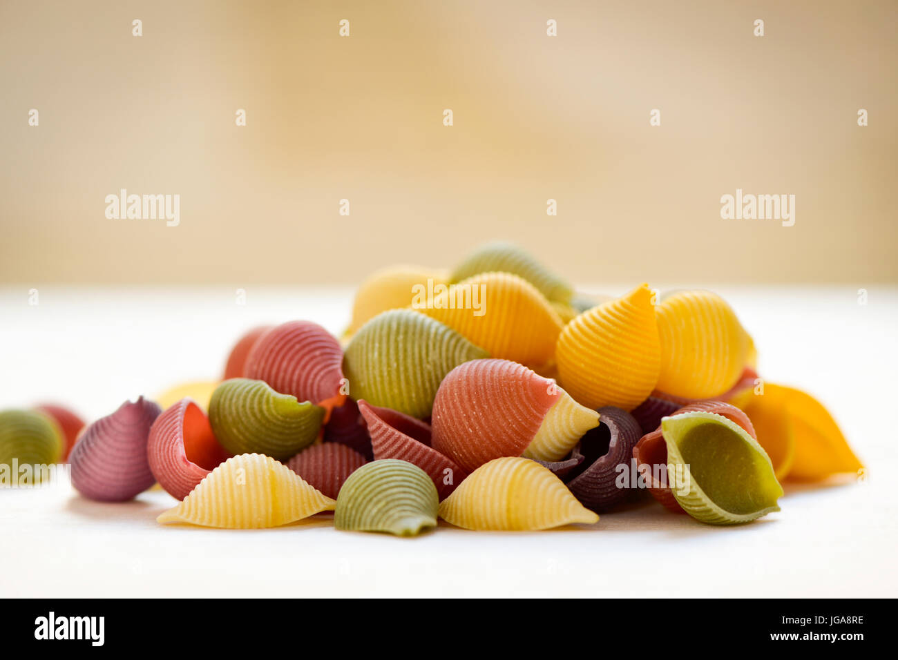 a pile of uncooked conchiglie, italian seashell pasta, with different ...