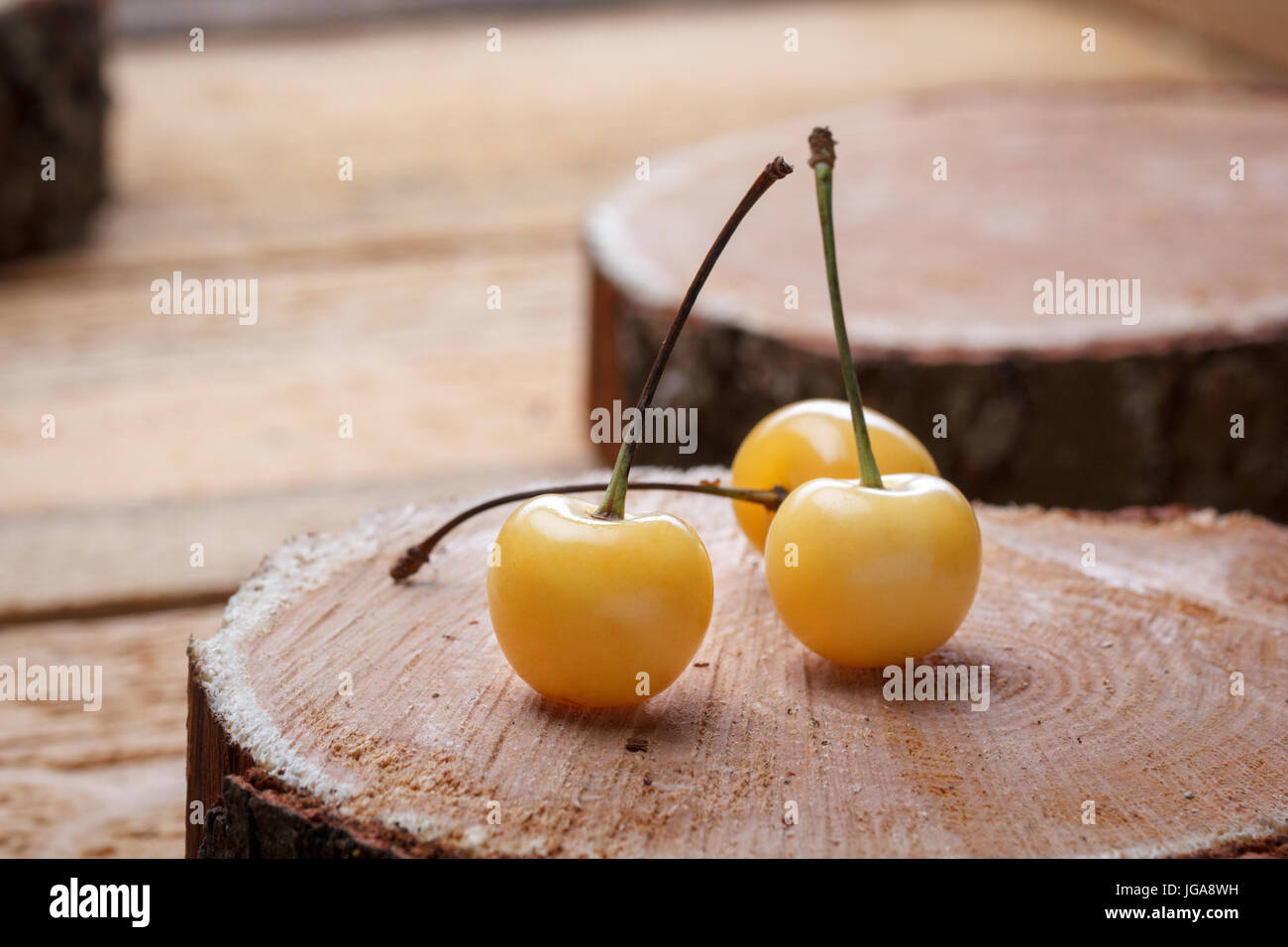 Yellow fresh cherry on a rustic wooden table. Berries on a wooden cut ...