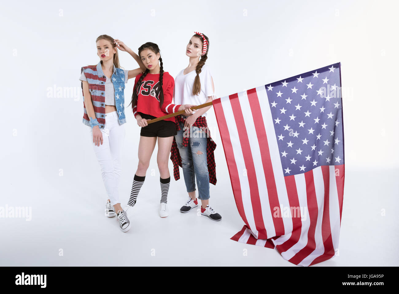 stylish young women posing with american flag in hands isolated on ...