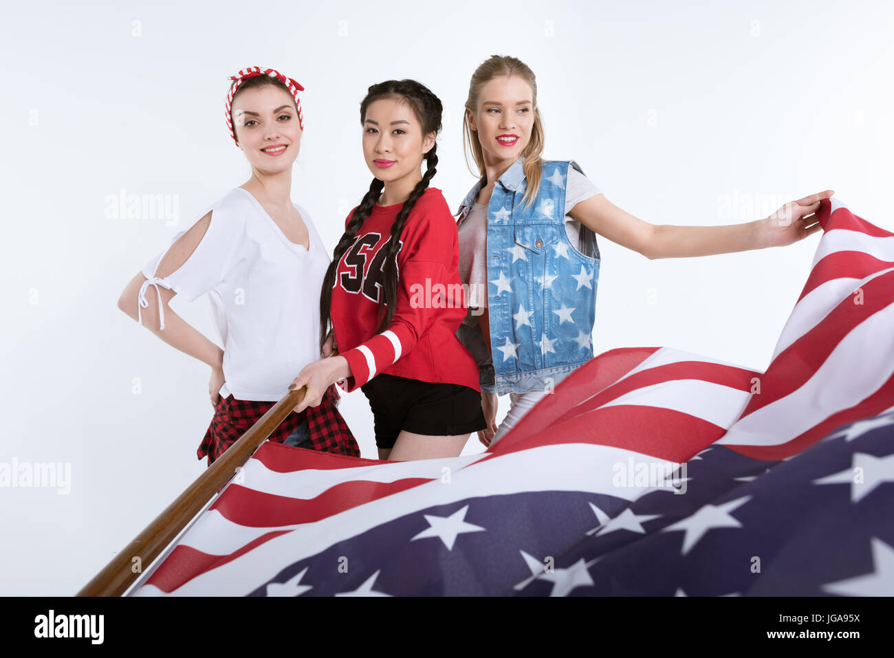 stylish young women posing with american flag in hands isolated on ...