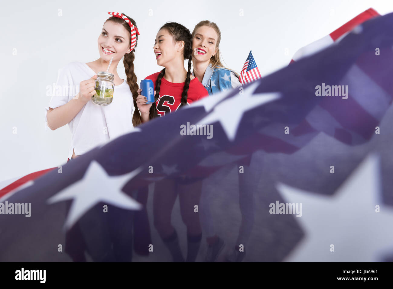 young women with american flag drinking beverages isolated on white ...