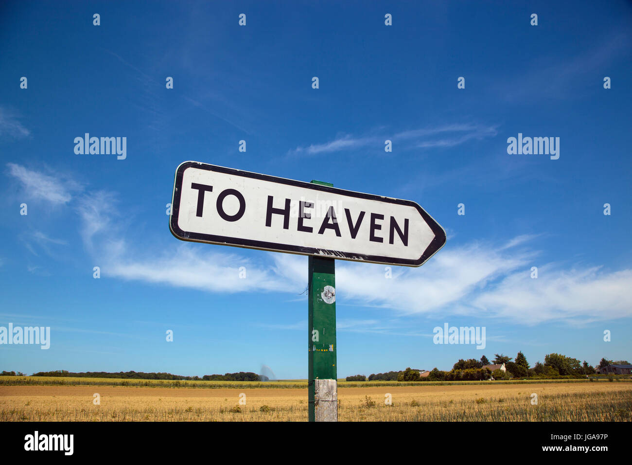 In the countryside a road sign with the inscription heaven, with a blue ...